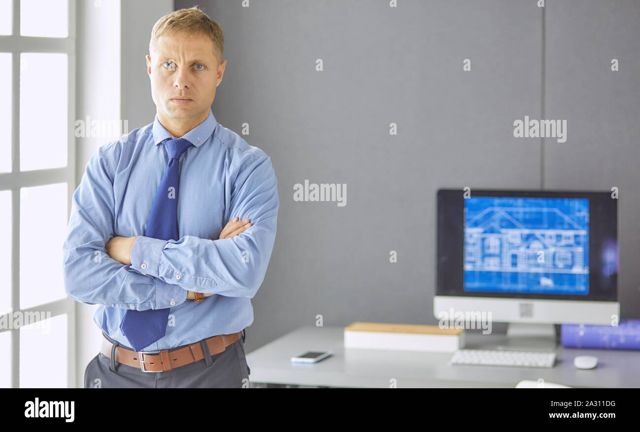 Happy businessman standing behind office desk, smiling Stock Photo - Alamy
