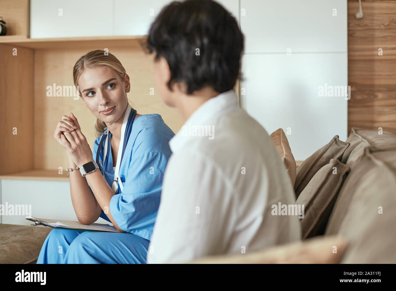 Friendly smiling doctor and patient sitting on the couch. Very good ...