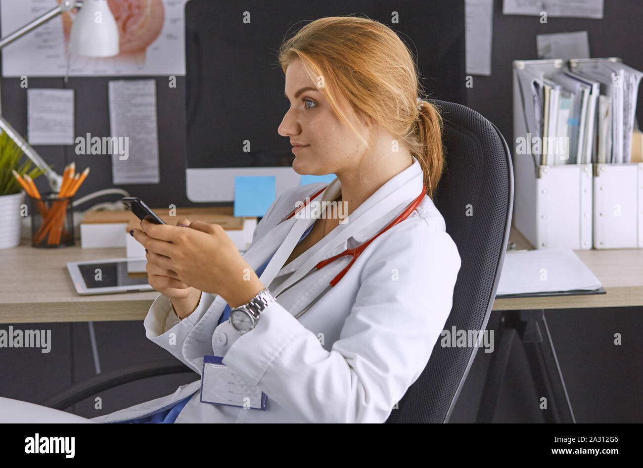 female doctor between patients in the office talking on the phone Stock ...