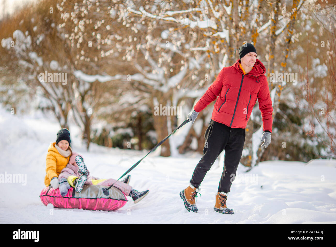 Little kids enjoy a sleigh ride. Family sledding. Children play ...