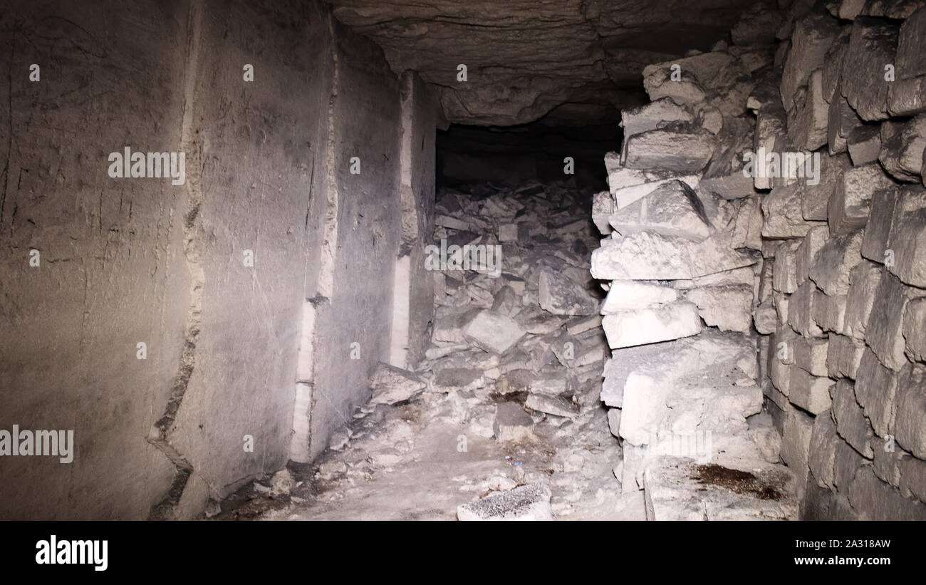 Old underground passage, dungeon, catacombs lined with stones and slabs ...