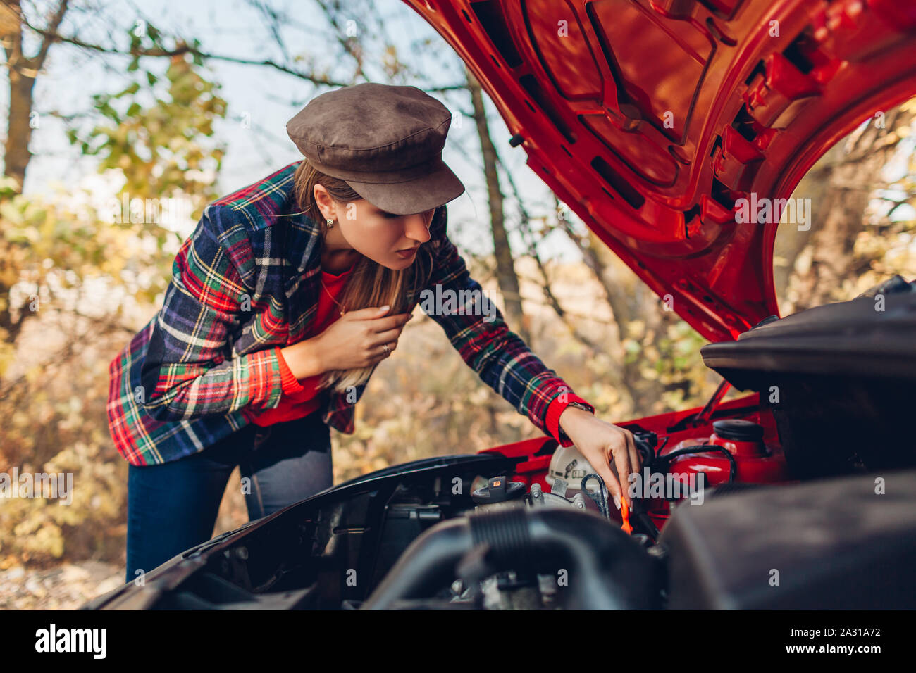 Car breakage. Woman opened hood of her auto that stopped on road and ...