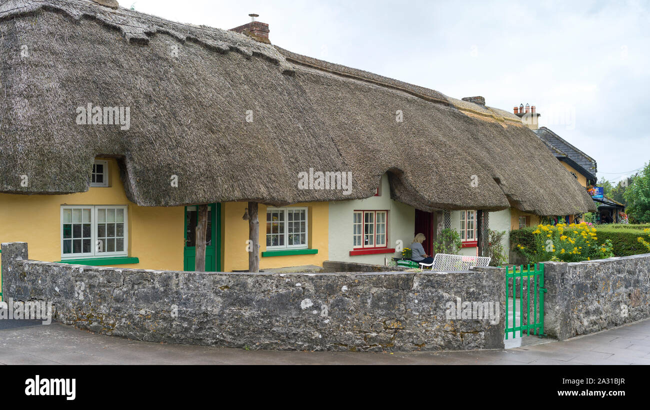 Fa ade of traditional thatch roof cottages, Adare, County Limerick ...