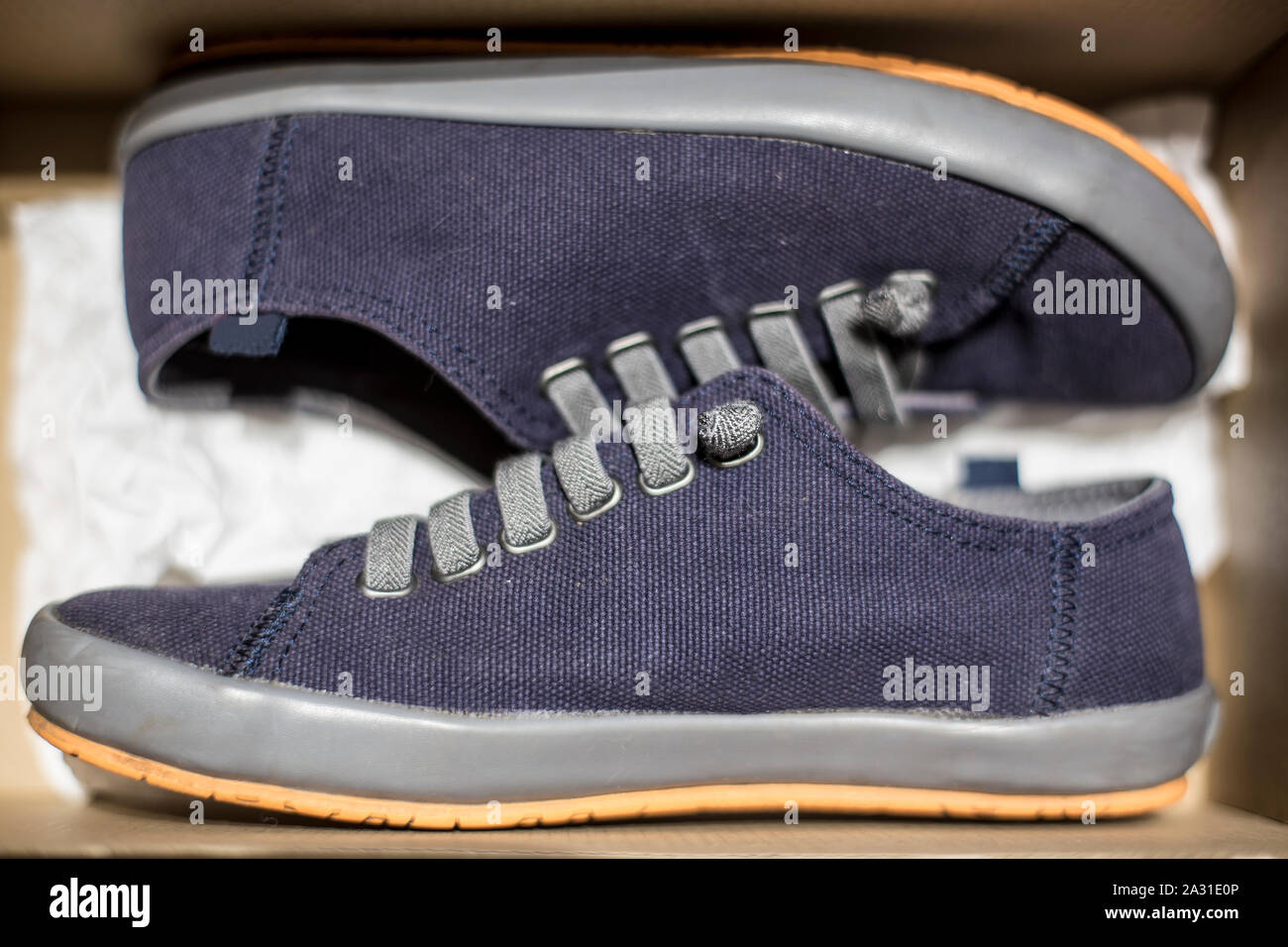 Stylish blue sneakers are stored inside a cardboard box. Close-up Stock ...
