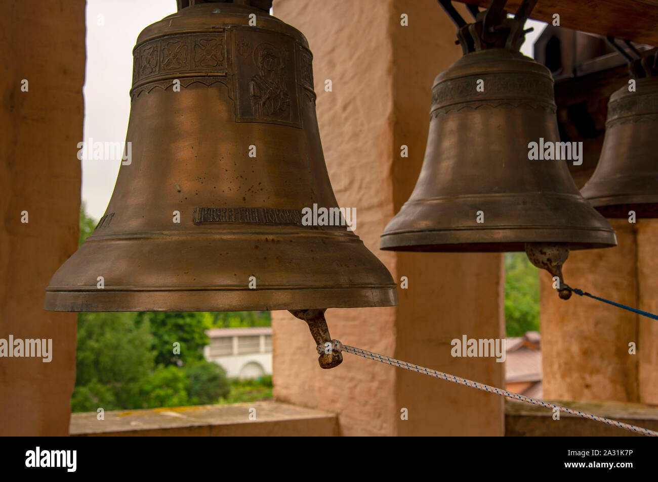 Bells of various sizes hang from a thick wooden beam Stock Photo - Alamy