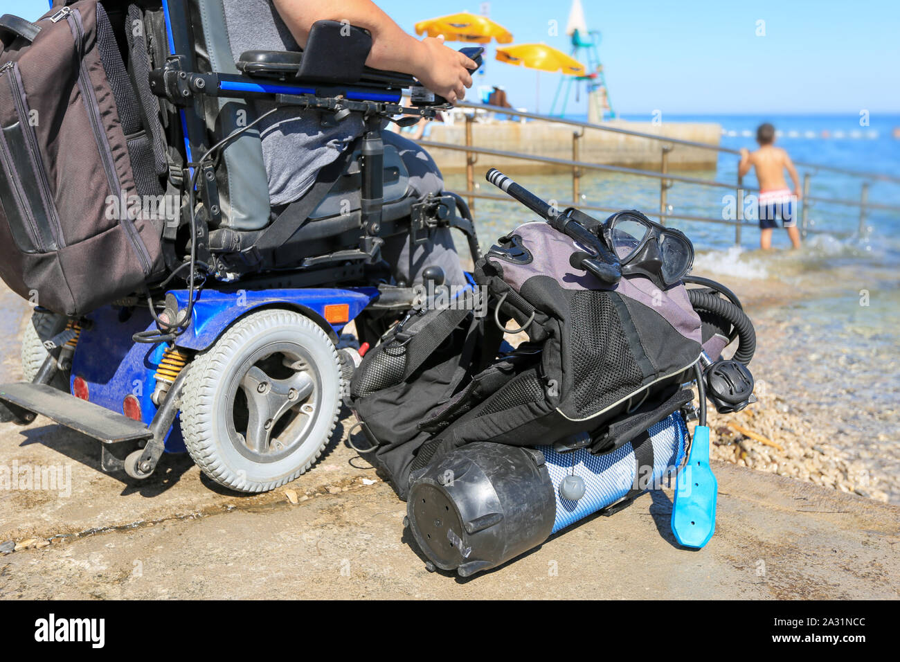 Handicapped disabled scuba diver with equipment on a beach shore ...