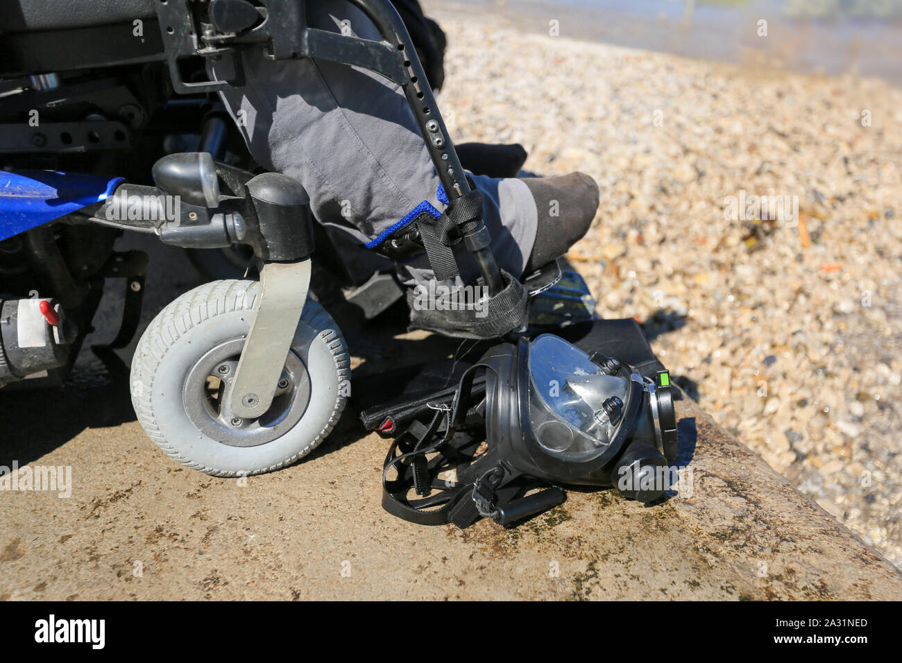Handicapped disabled scuba diver with equipment on a beach shore ...