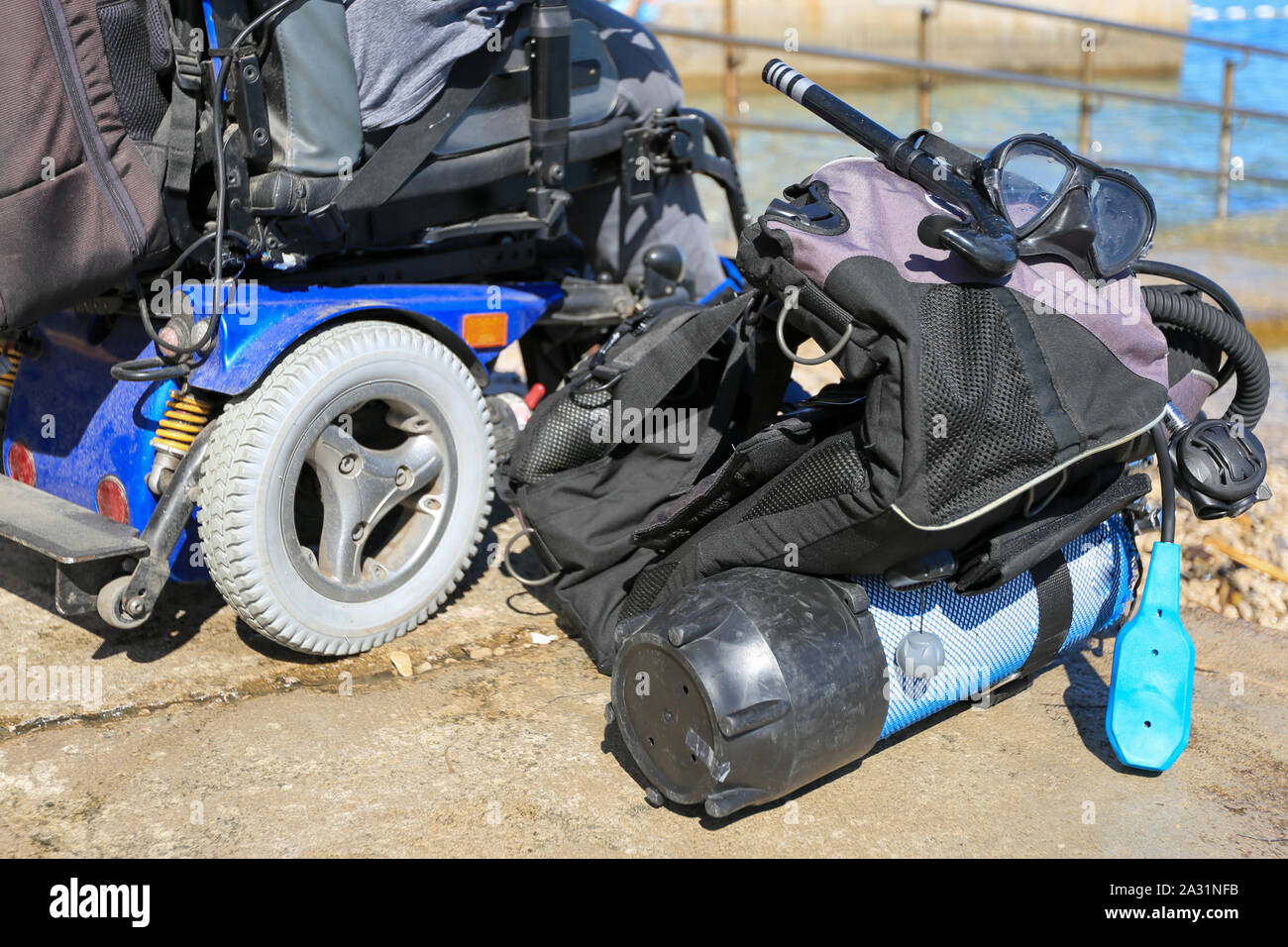 Handicapped disabled scuba diver with equipment on a beach shore ...