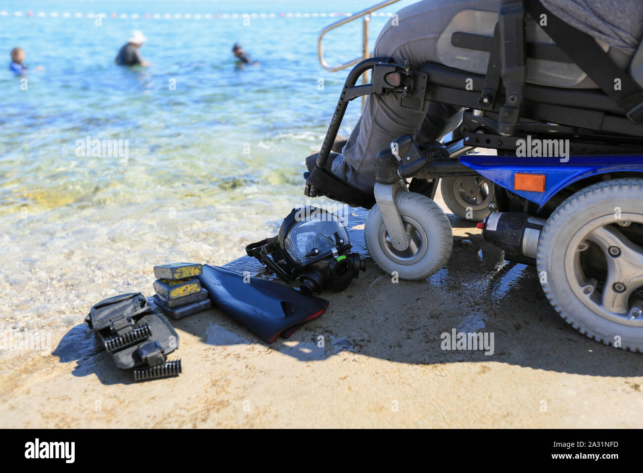 Handicapped disabled scuba diver with equipment on a beach shore ...