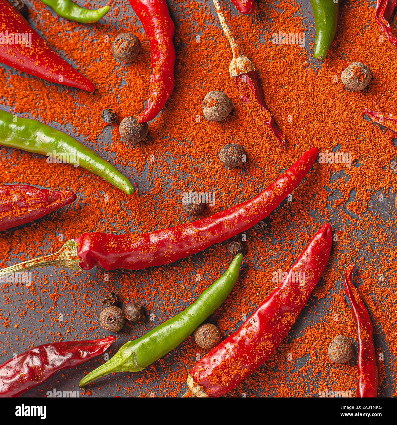 A lot of red and green pepper and pepper. Sprinkle paprika on a black ...