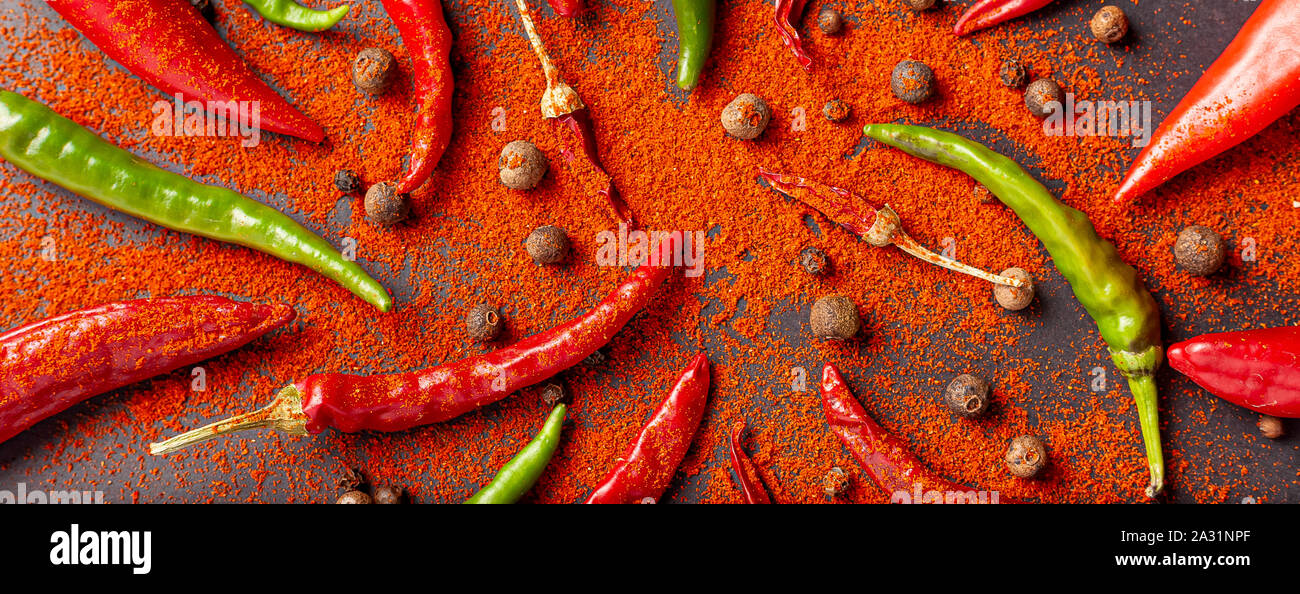 A lot of red and green pepper and pepper. Sprinkle paprika on a black ...