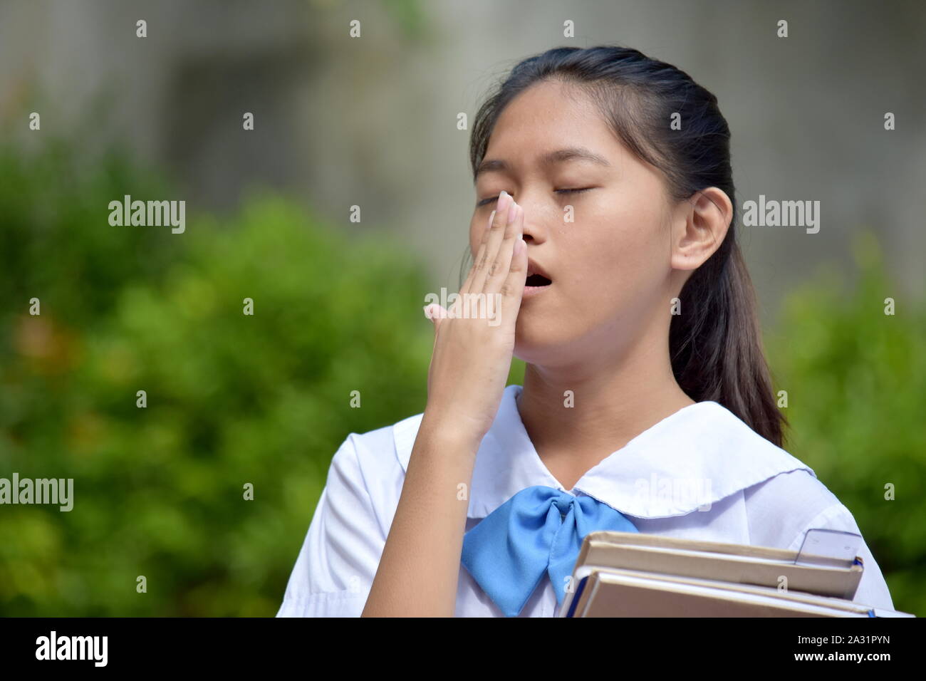 Youthful Female Student Yawning With School Books Stock Photo - Alamy