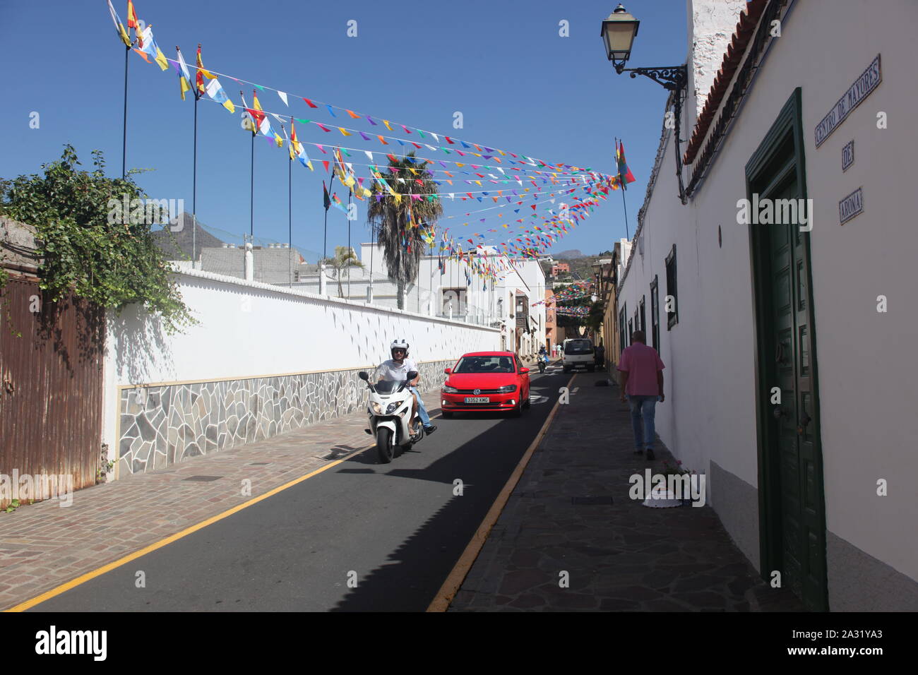 Wide-angle street view of white motorcycle and red car driving down a ...