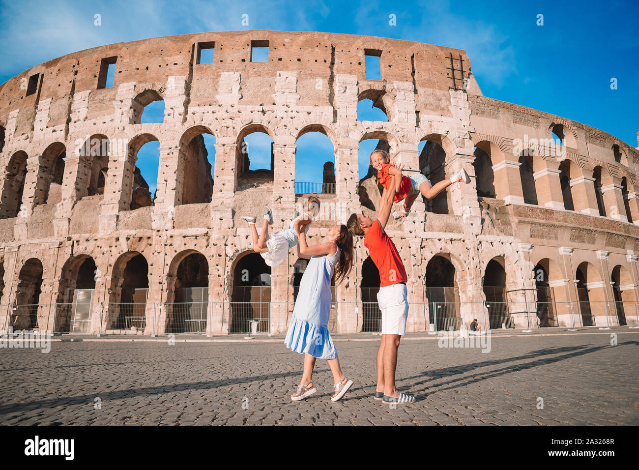 Happy parents with kids on roman vacations in Rome over Coliseum ...