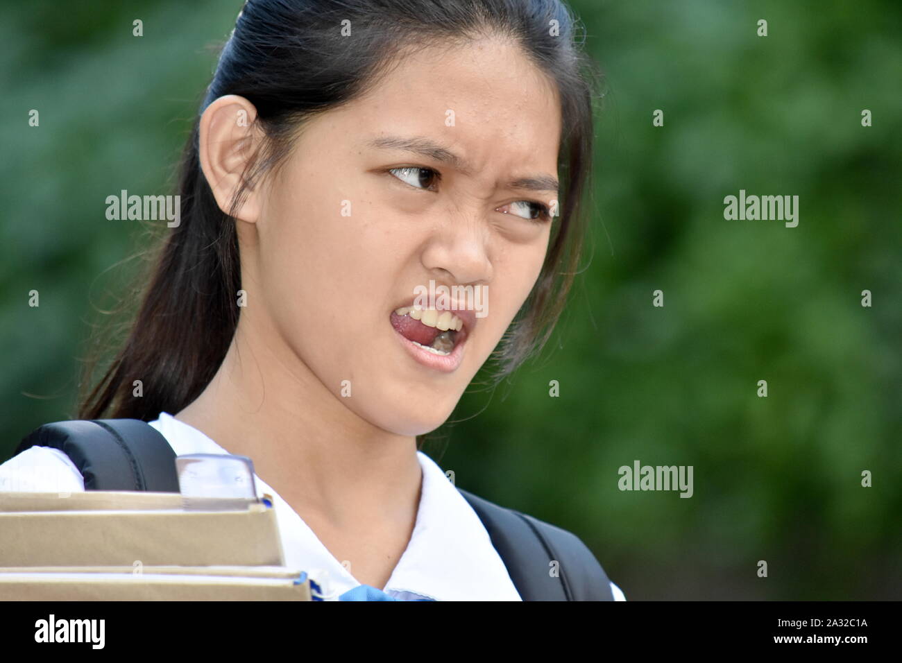 Angry Pretty Female Student With School Books Stock Photo - Alamy
