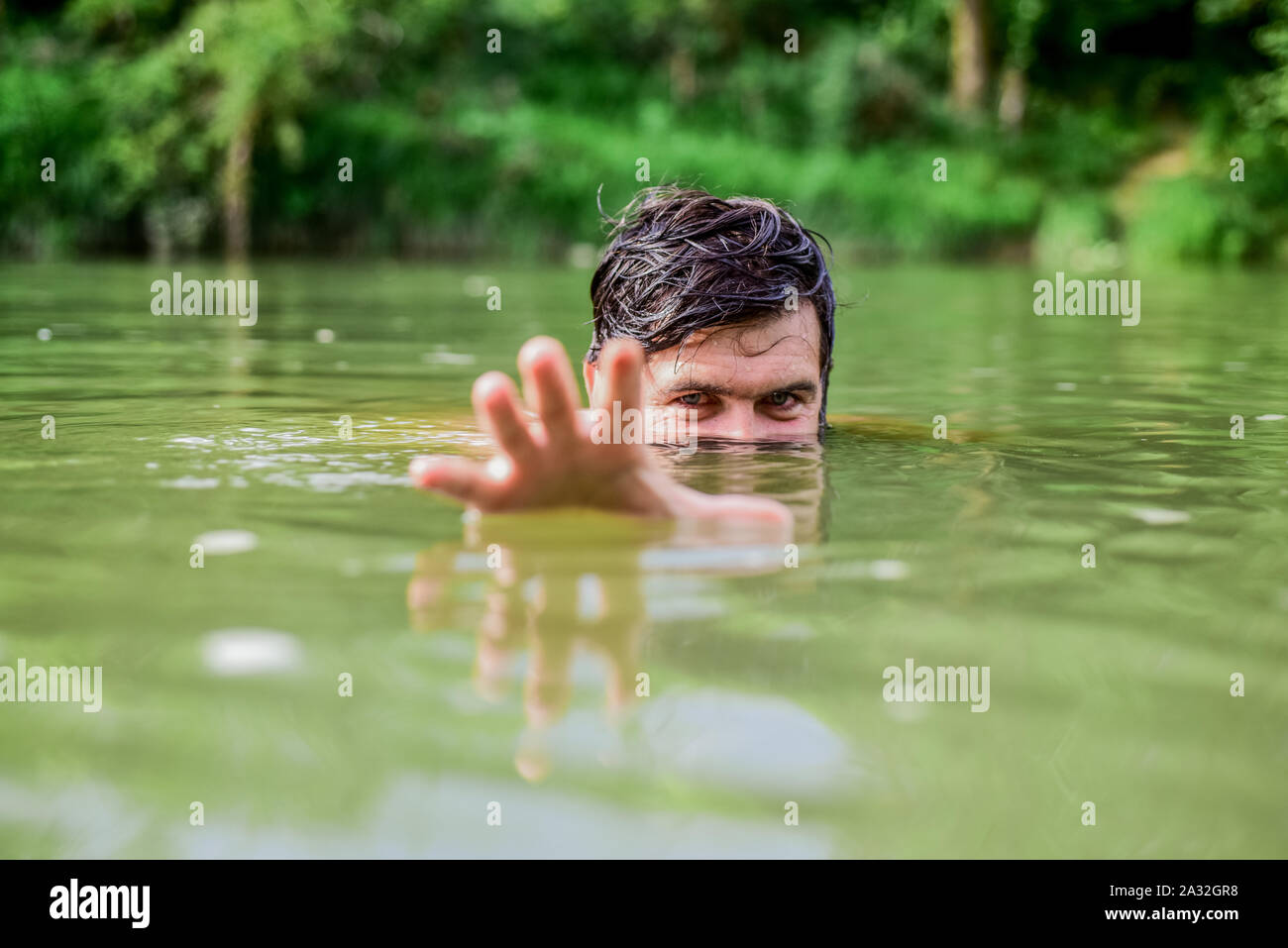 scary man comes from deep water. bearded man swimming in lake. summer ...