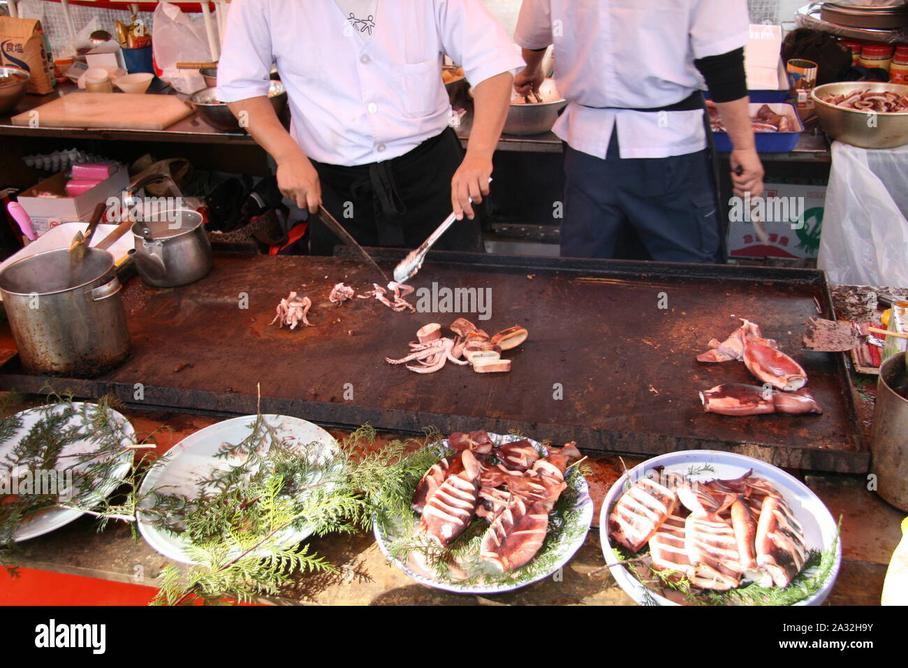 Two Japanese chefs prepare seafood on a grill j Stock Photo - Alamy