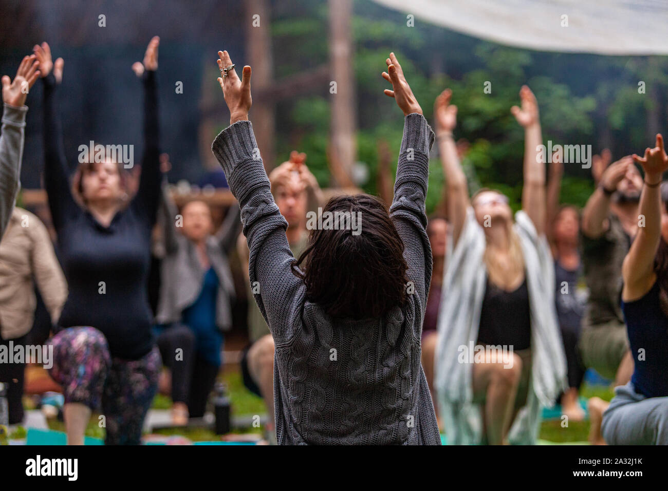 A large group of multigenerational people are seen in a peaceful yoga ...