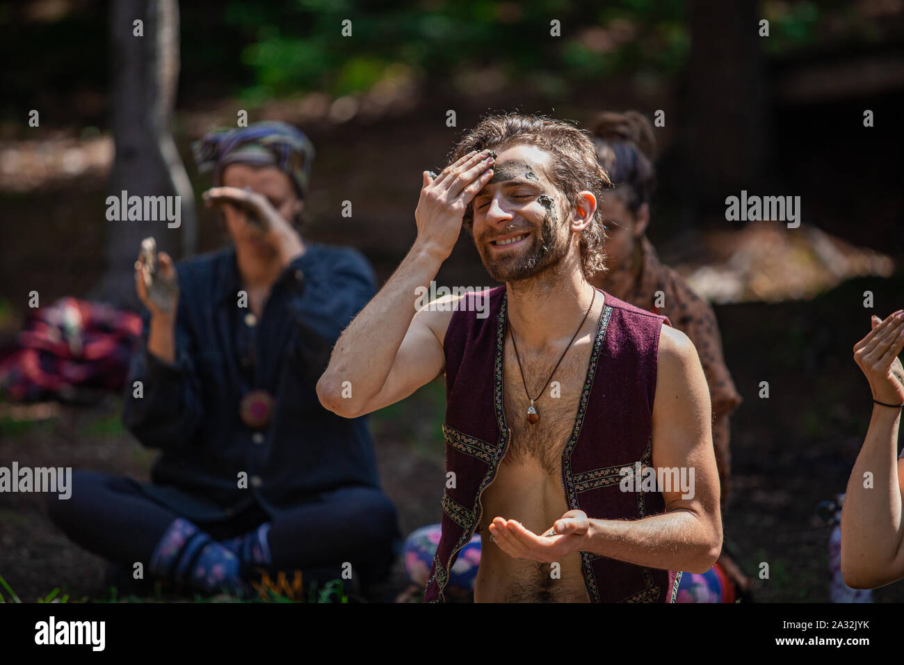 A mystical and enlightened man is viewed from the front, smiling as he ...