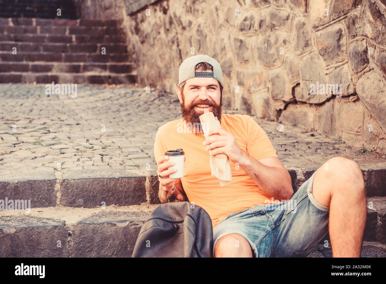 Hungry man snack. Junk food. Guy eating hot dog. Man bearded enjoy ...
