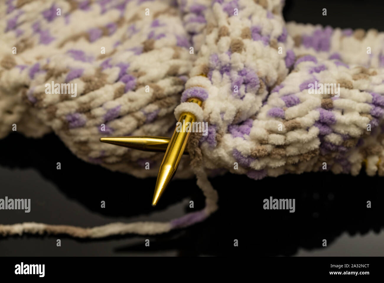 handicraft and needlework concept - close up of knitting needles and ...