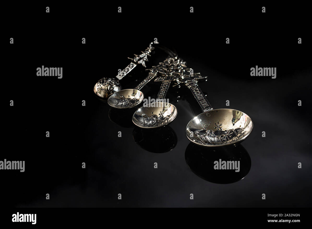 Silver ornamental christmas measuring cups with black background Stock ...