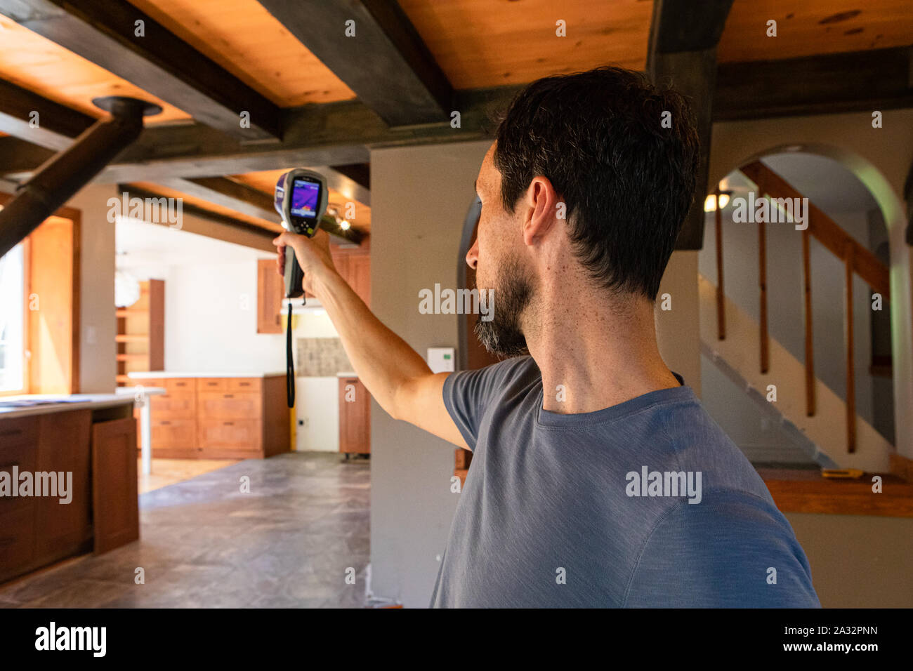 A closeup view of a caucasian man using a hand held infrared spot ...