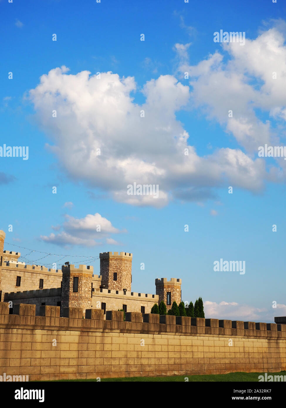 A long wall of battlements in front of a medieval style stone castle ...
