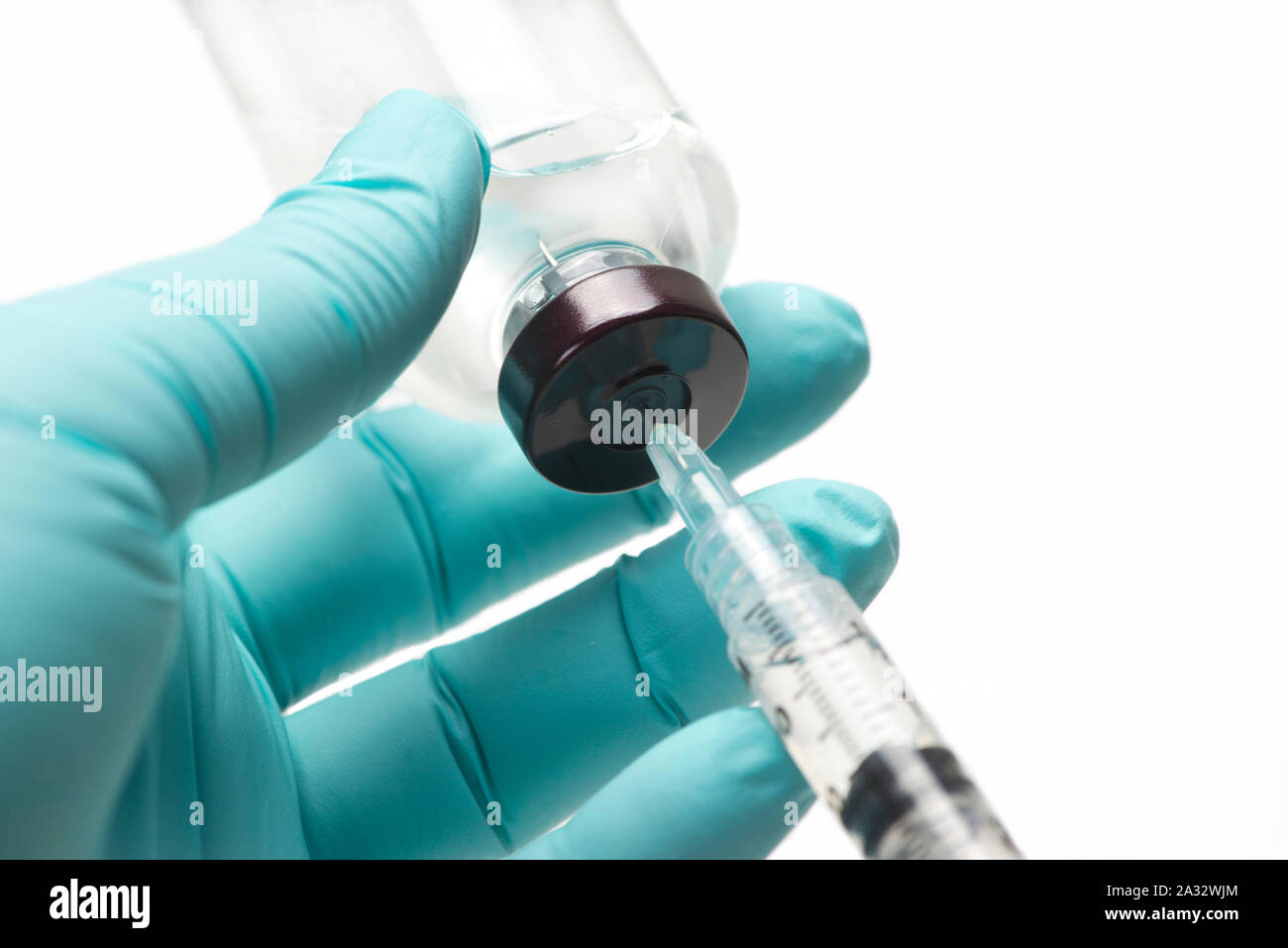 Gloved hand draws liquid into syringe from large vial Stock Photo - Alamy