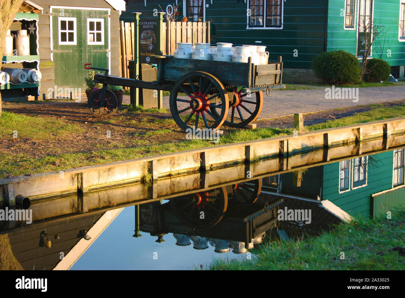 traditional wooden milk cart loaded with antique containers in front of ...
