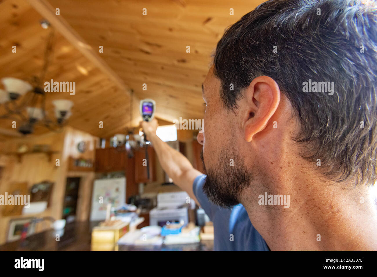 A close up and rear view of a man using an infrared thermovision device ...