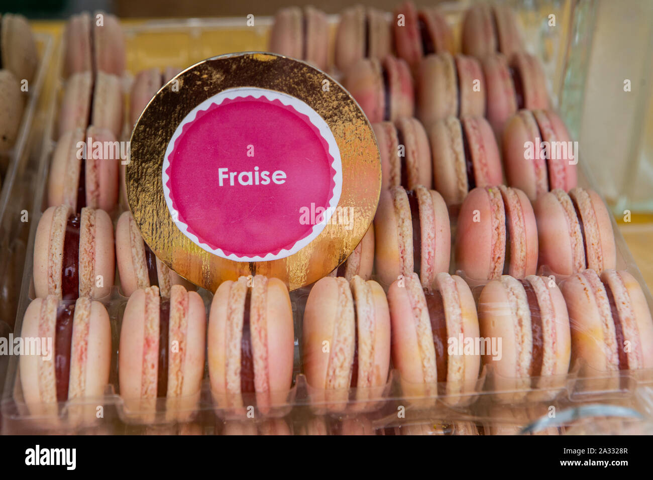 A close up view of light pink colored strawberry flavored macarons on a ...