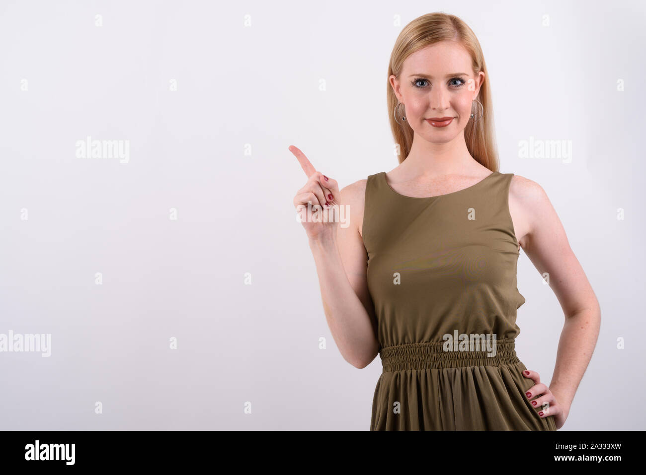 Young beautiful British woman with blond hair against white background ...