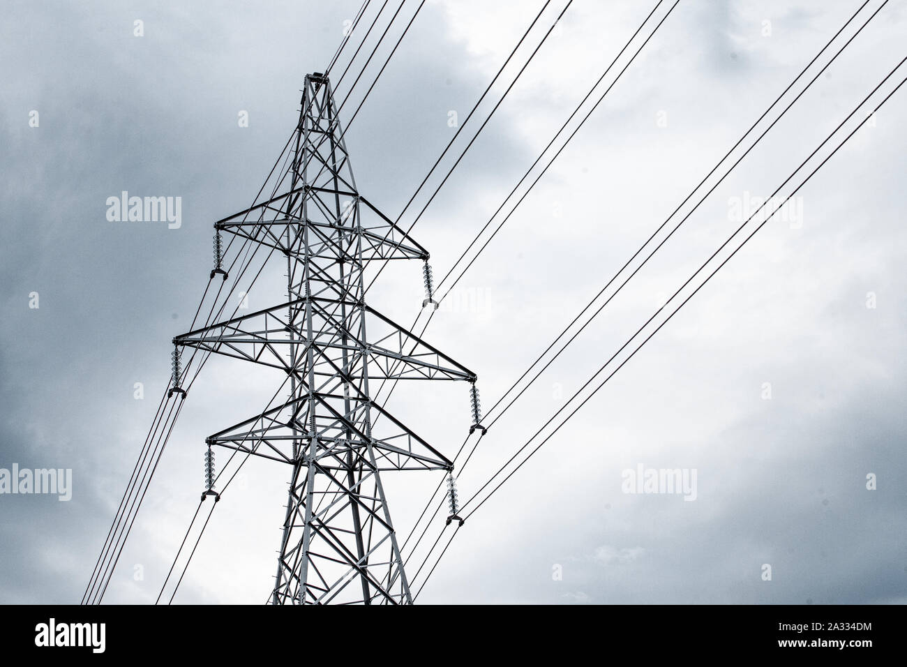 A low-angled view of a tall steel lattice electricity pylon with ...