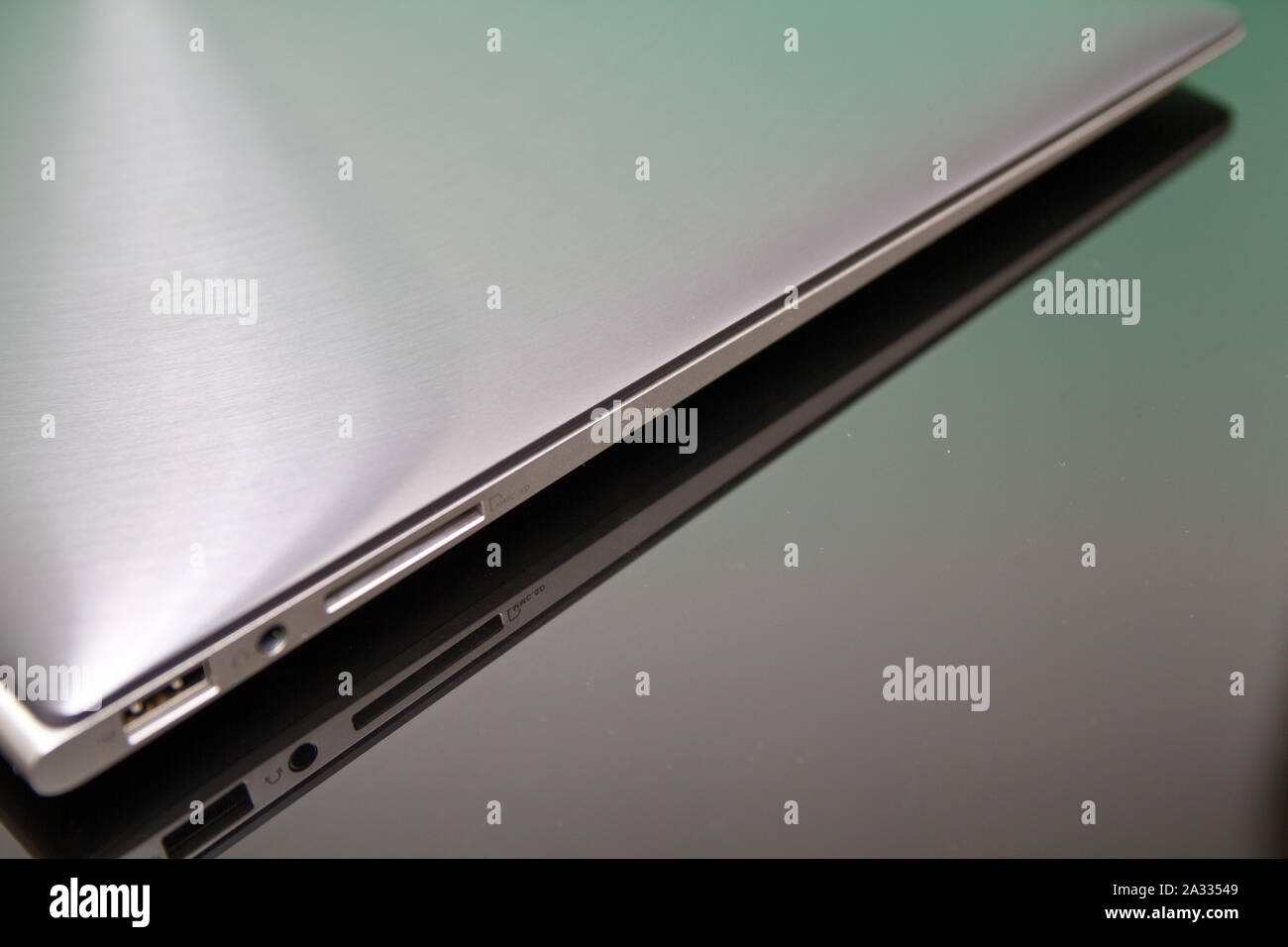 metal-finished laptop computer on reflective surface Stock Photo - Alamy