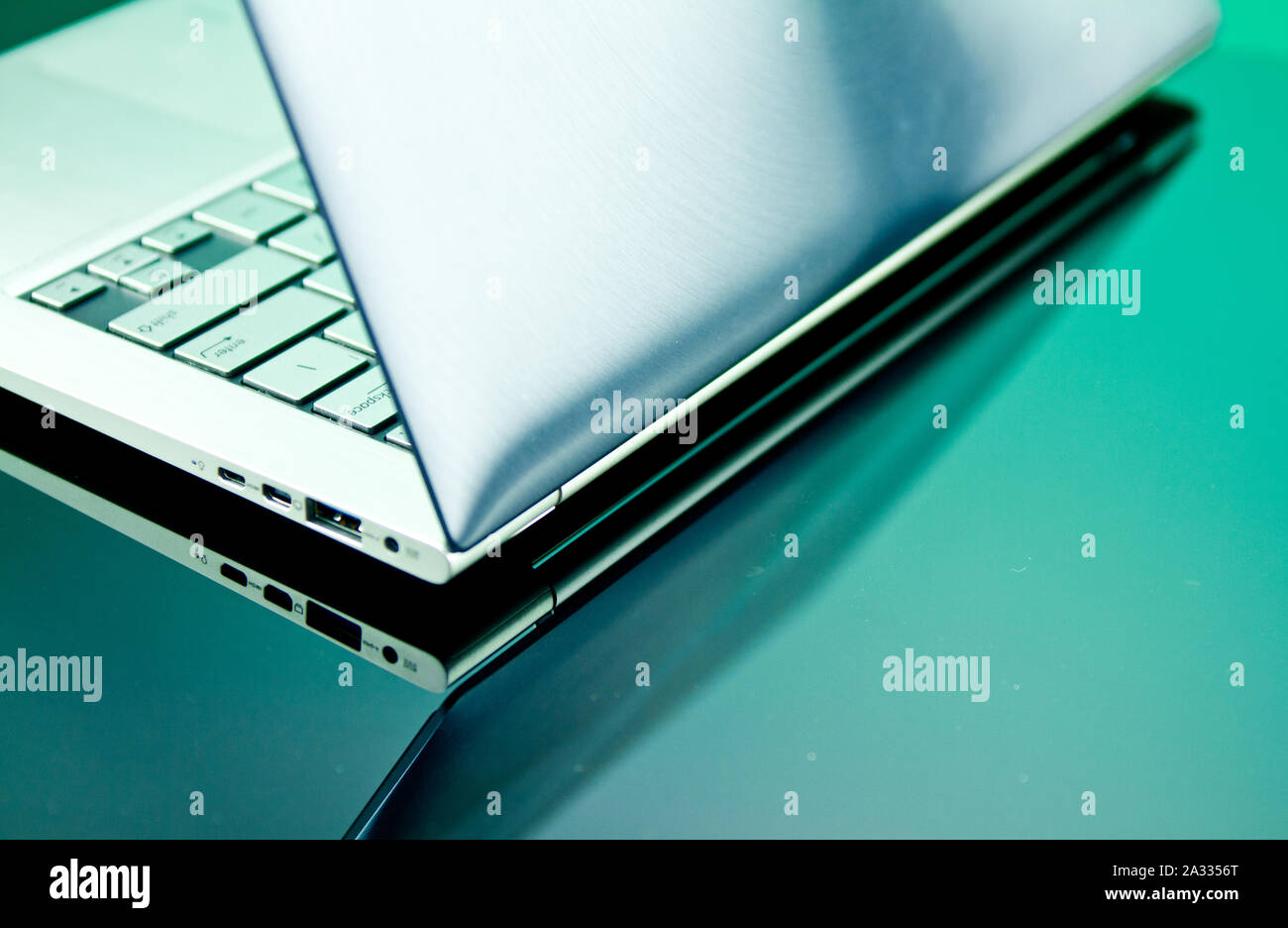 metal-finished laptop computer on reflective surface Stock Photo - Alamy