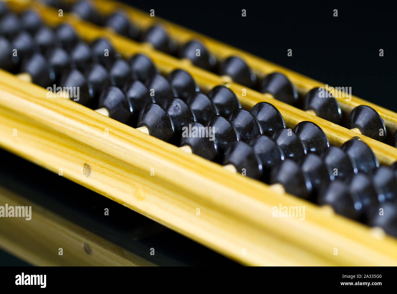 abacus with black beads on black reflective surface Stock Photo - Alamy