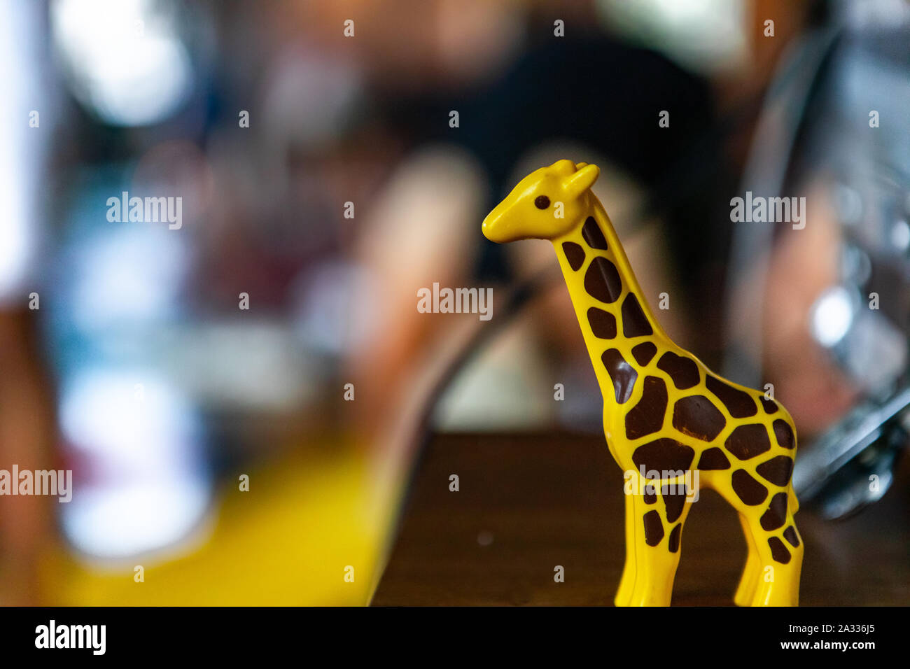 A close up and side profile view of a cute and colorful plastic giraffe ...