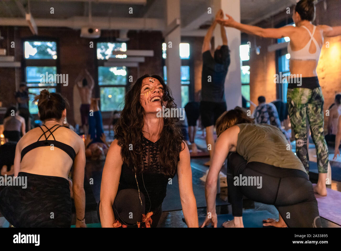 An elated woman is seen in lying cobra pose during class dedicated to ...