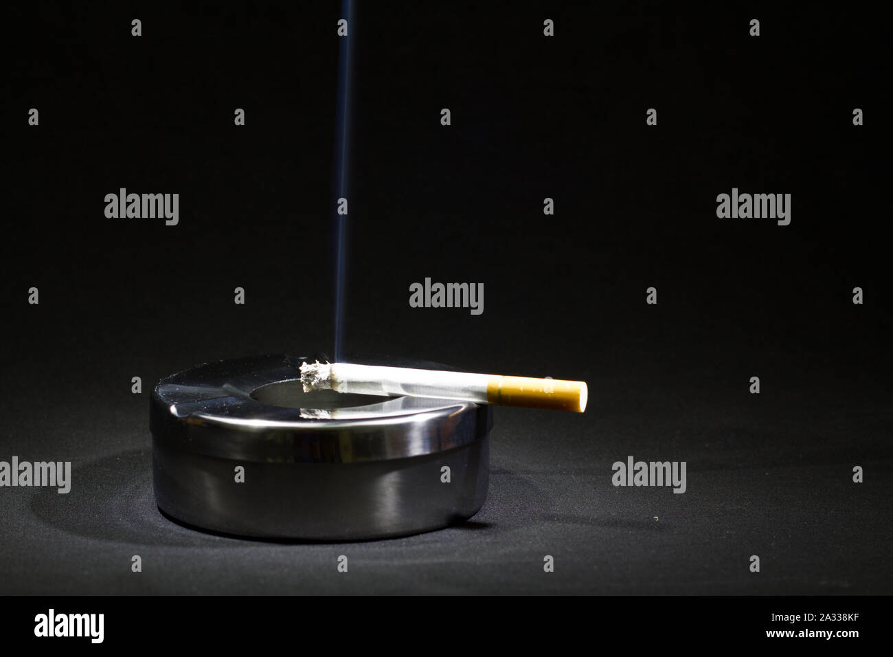 cigarette ashtray with burning cigarette on dark background Stock Photo ...