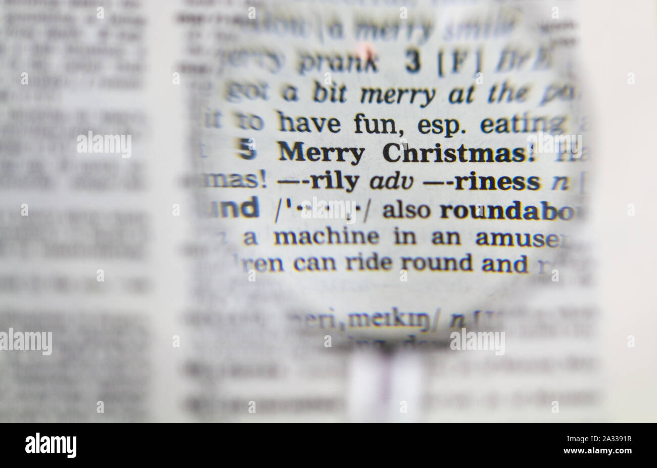the word merry Christmas definition in old dictionary under magnifying ...