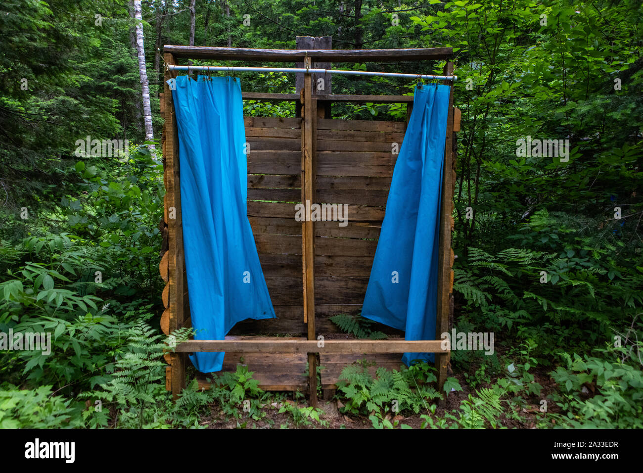 Basic wash and hygiene facilities are viewed in dense woodland, at a ...