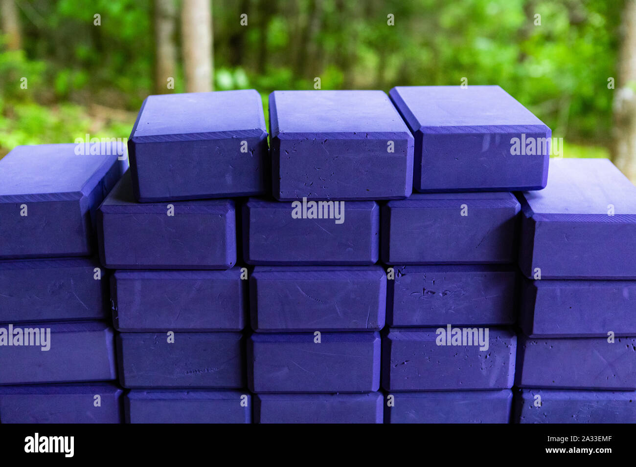 A closeup view of a pile of blue bricks, objects stored near a woodland ...