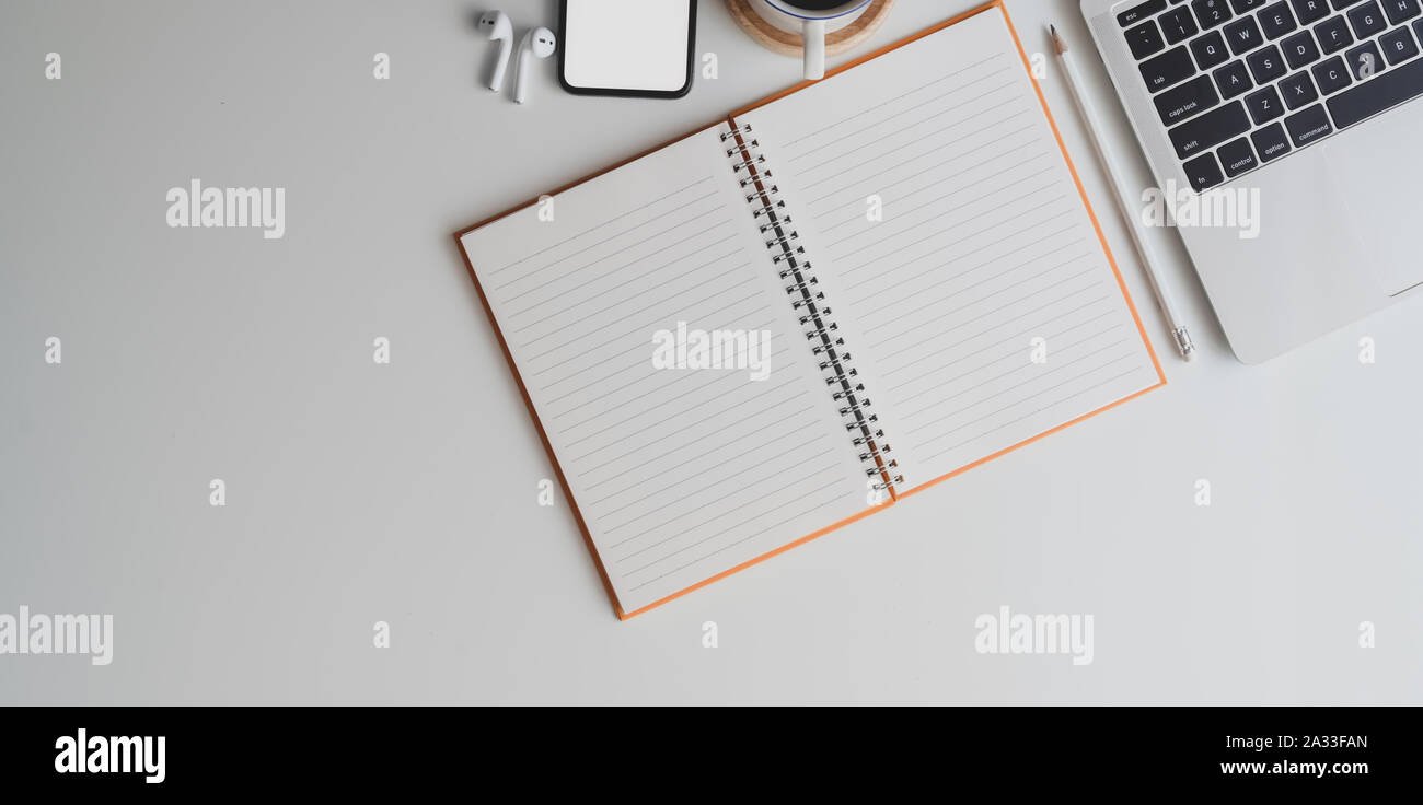 Overhead shot of comfortable workplace with open blank notebook on ...