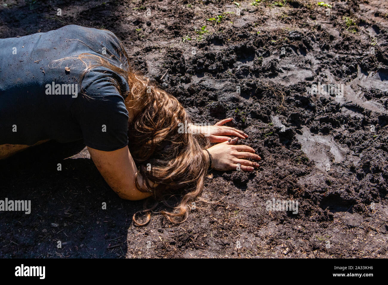 A closeup view of a young brunette woman, crouched over face down in a ...