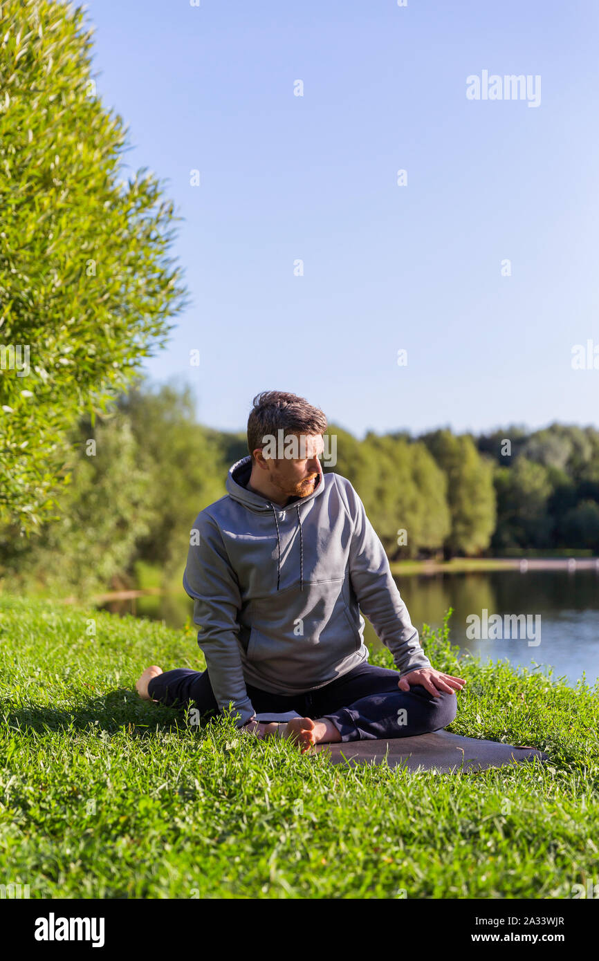 Inspired man doing yoga asanas in city park. Fitness outdoors and life ...