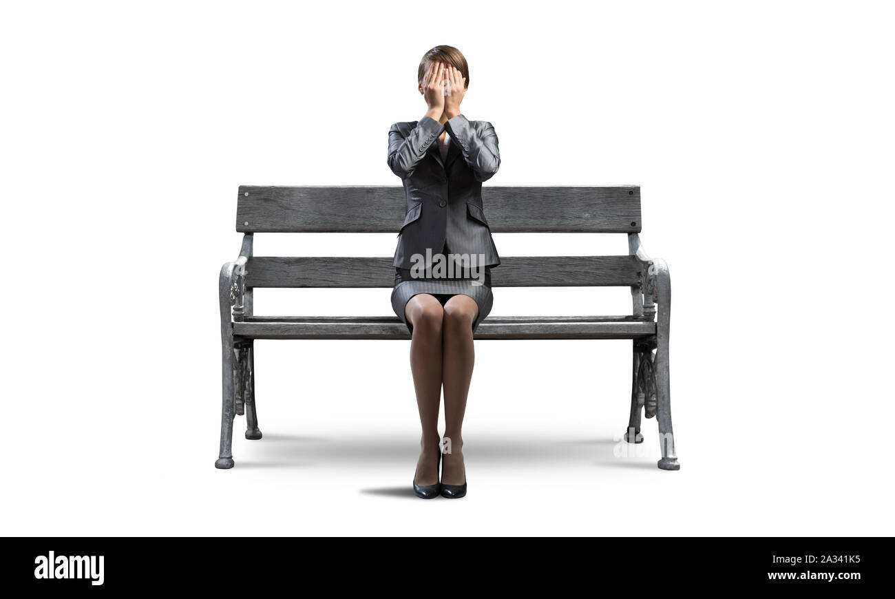 Sorrowful woman sitting on wooden bench. Shocked girl in business suit ...