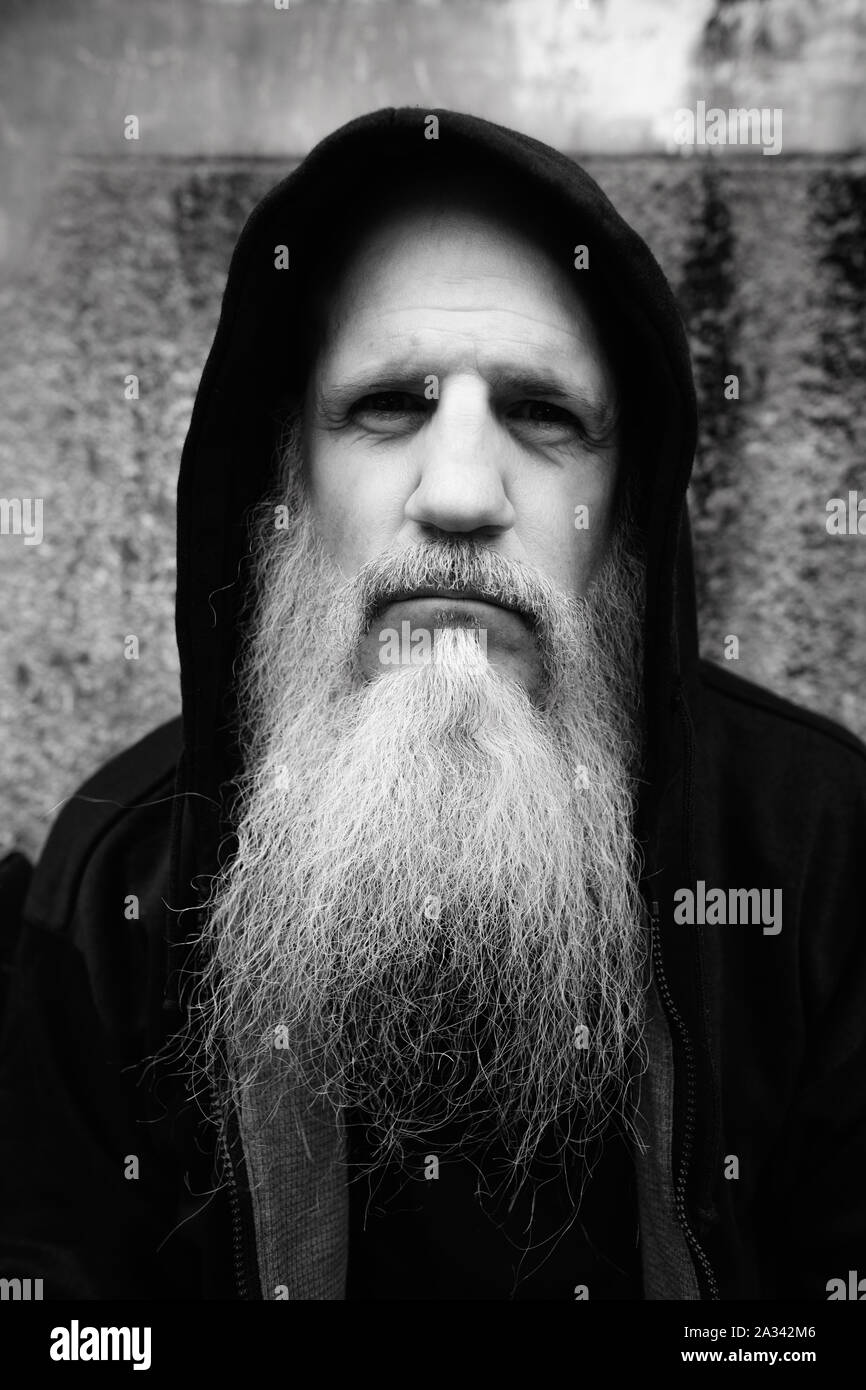Mature bald man with long gray beard wearing hoodie outdoors Stock ...