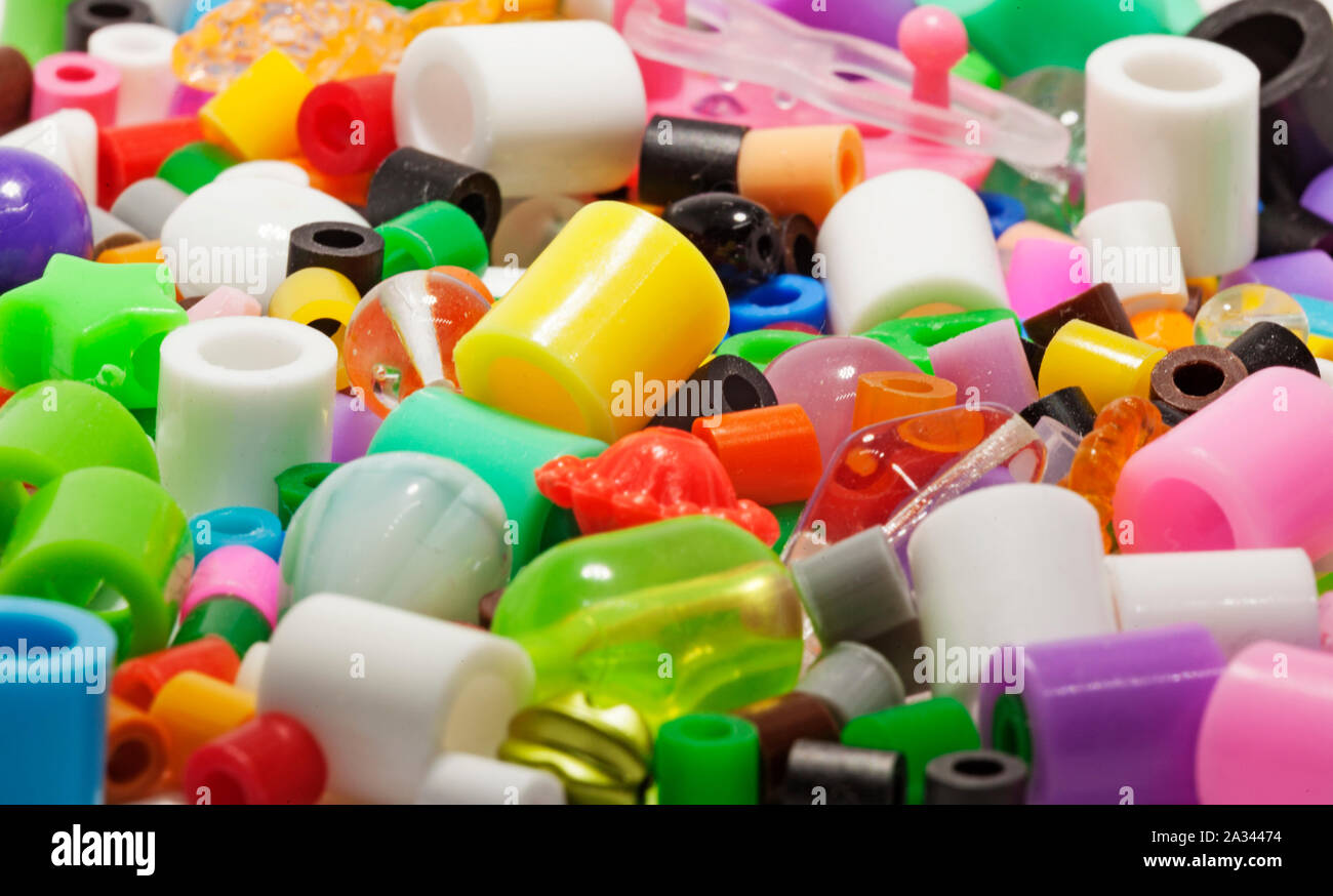 mixed beads in different colors and shapes on white background with ...