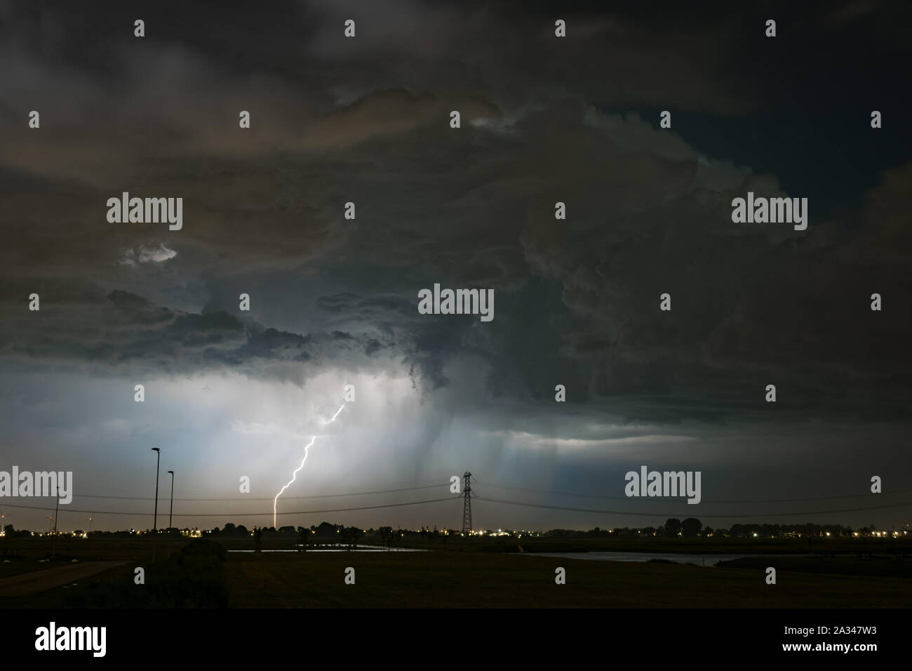 Lightning bolt strikes down to earth from a large storm cloud ...